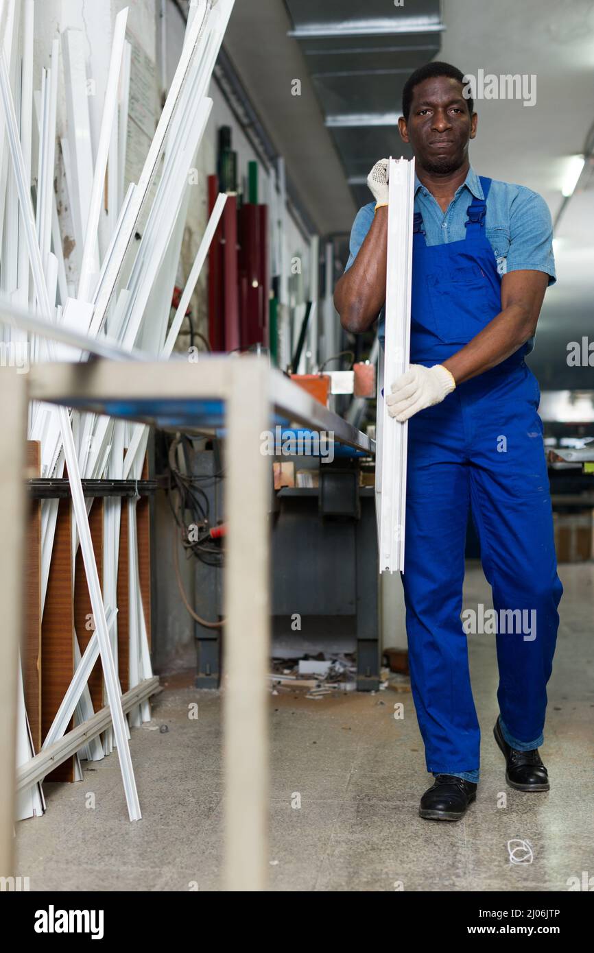 Portrait of man worker who is standing with window frame in the pvc ...