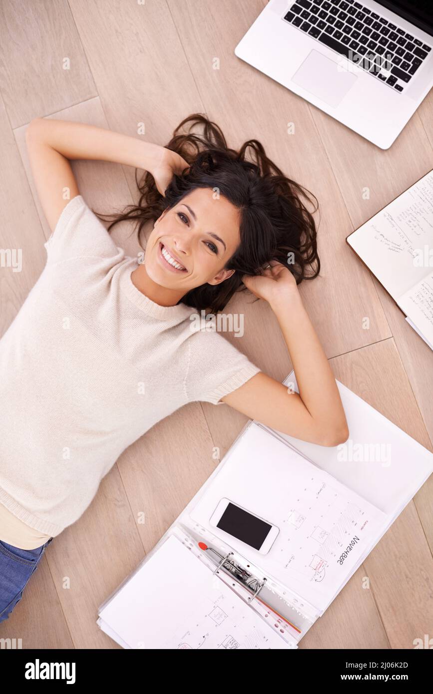 Study break. High angle shot of an attractive young woman lying on her ...