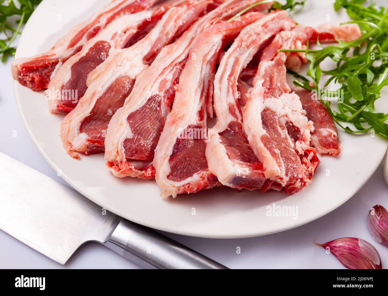 Chops of fresh raw lamb ribs with garlic and greenery. Ingredients for ...