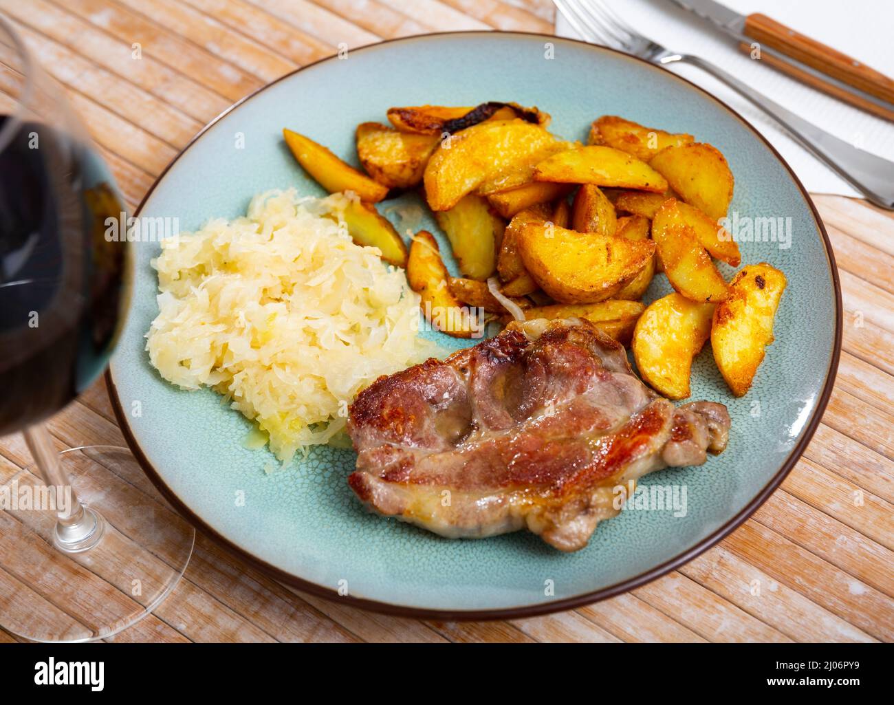 Delicious pork chop with side dish of crispy baked potato slices and ...