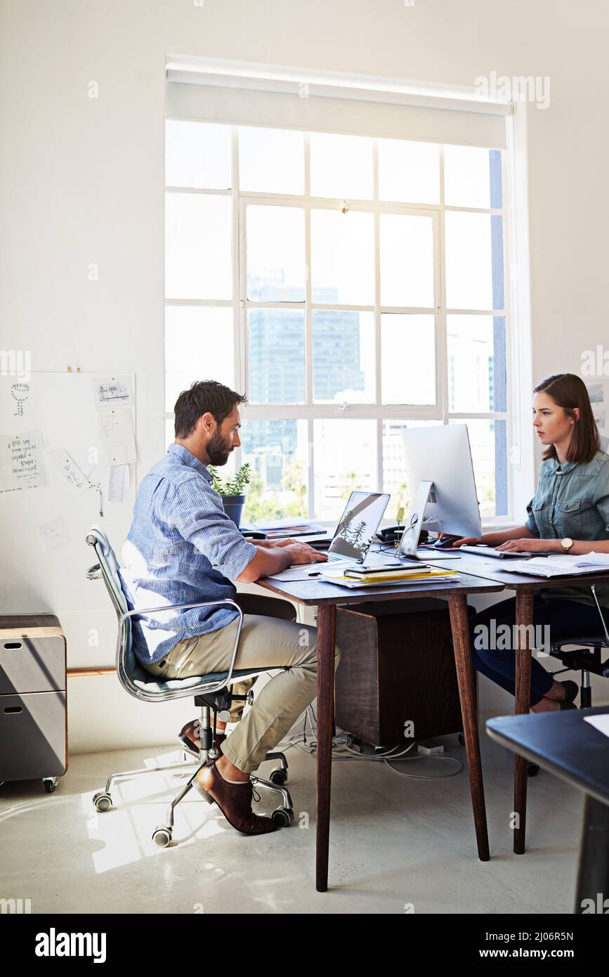 Designers online. Shot of colleagues working on their computers at a ...