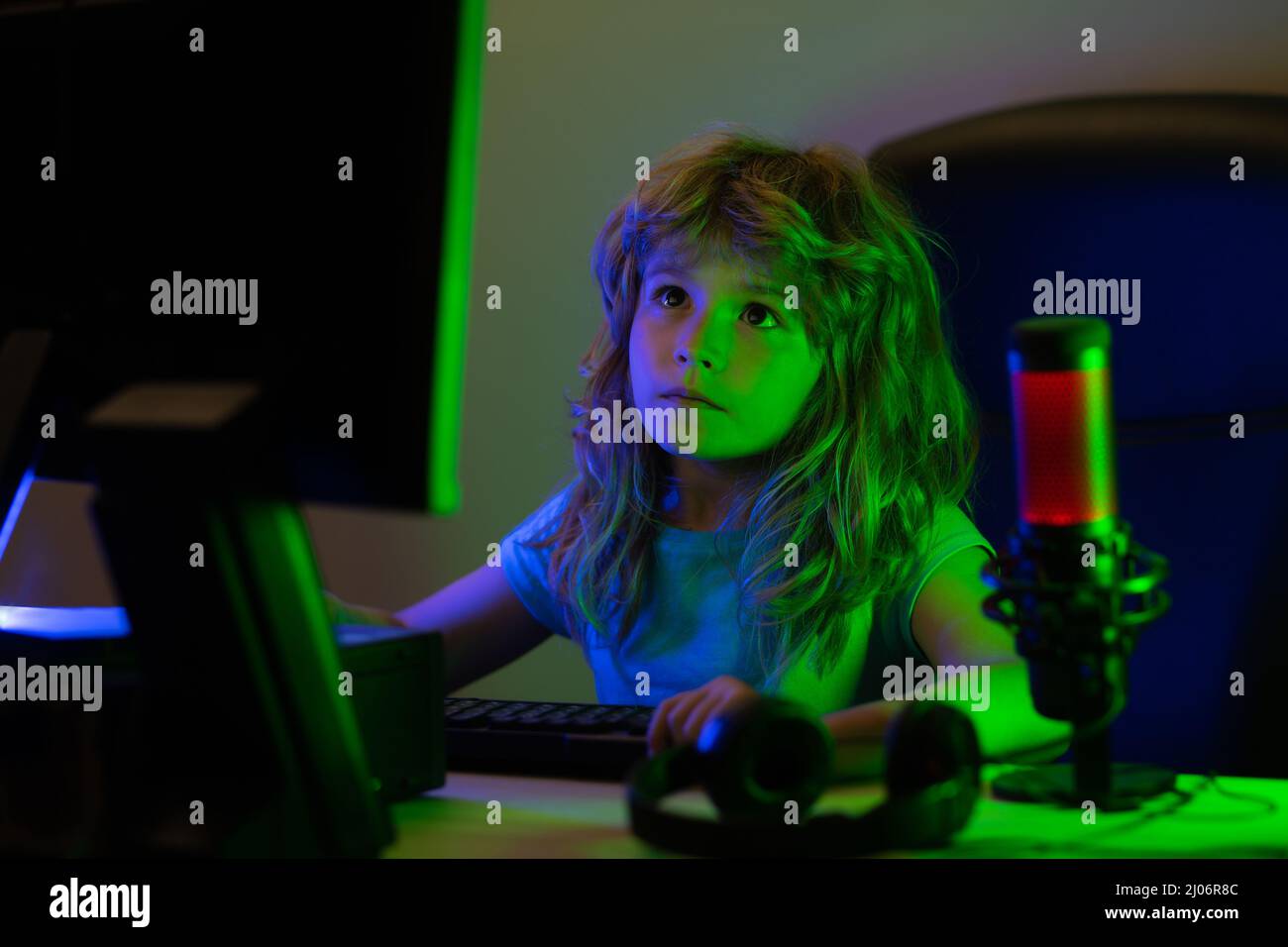 Little child gamer play computer game on desktop. Gaming stream and ...