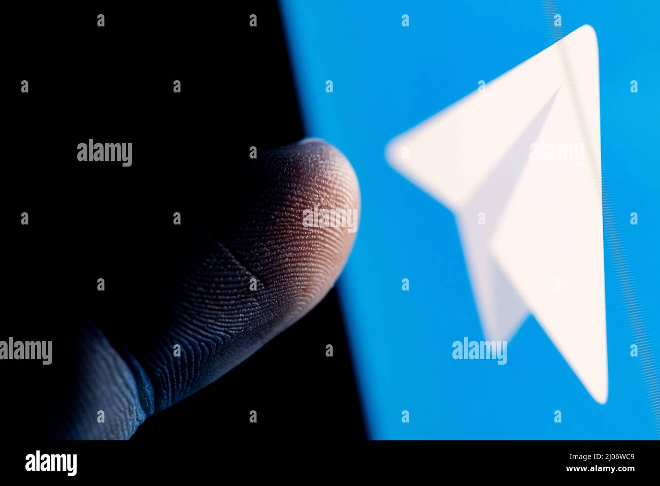 The finger reaches for the Telegram messenger logo on the smartphone ...
