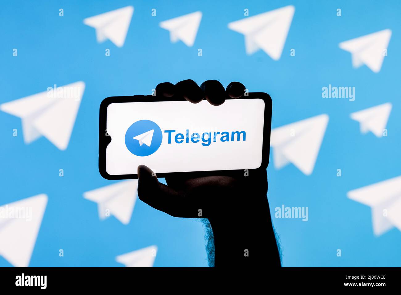 Smartphone with the Telegram messenger on the screen in a clenched hand ...