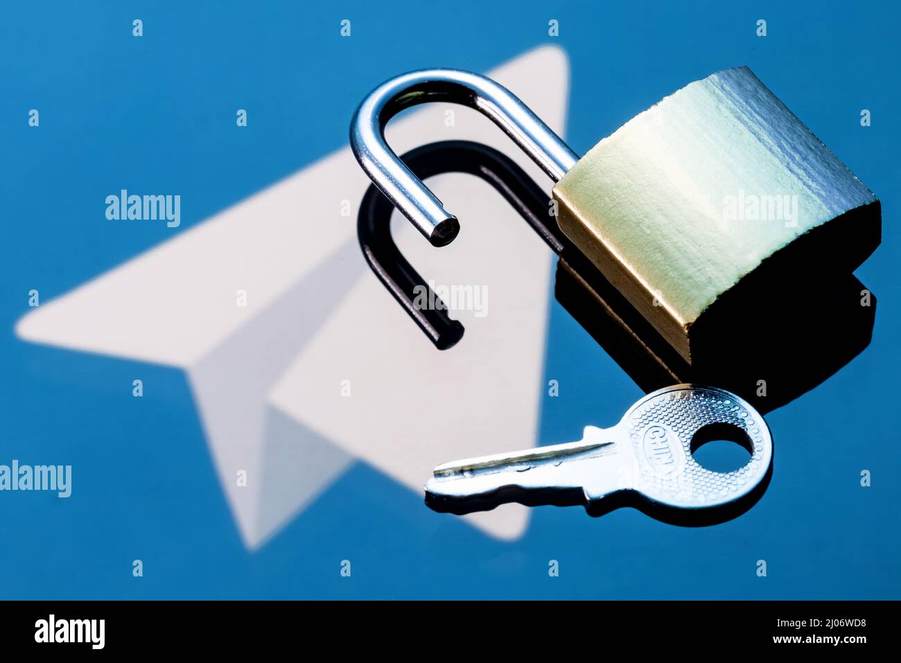 An open security lock and key on the background of the Telegram ...
