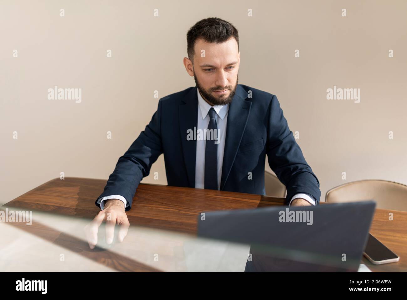 a man in a strict business suit works at the office walls behind a ...