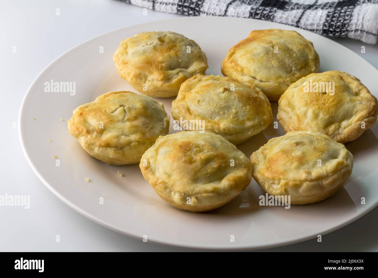 Mini steak pies on a plate - small baked wholesome pies close up on ...