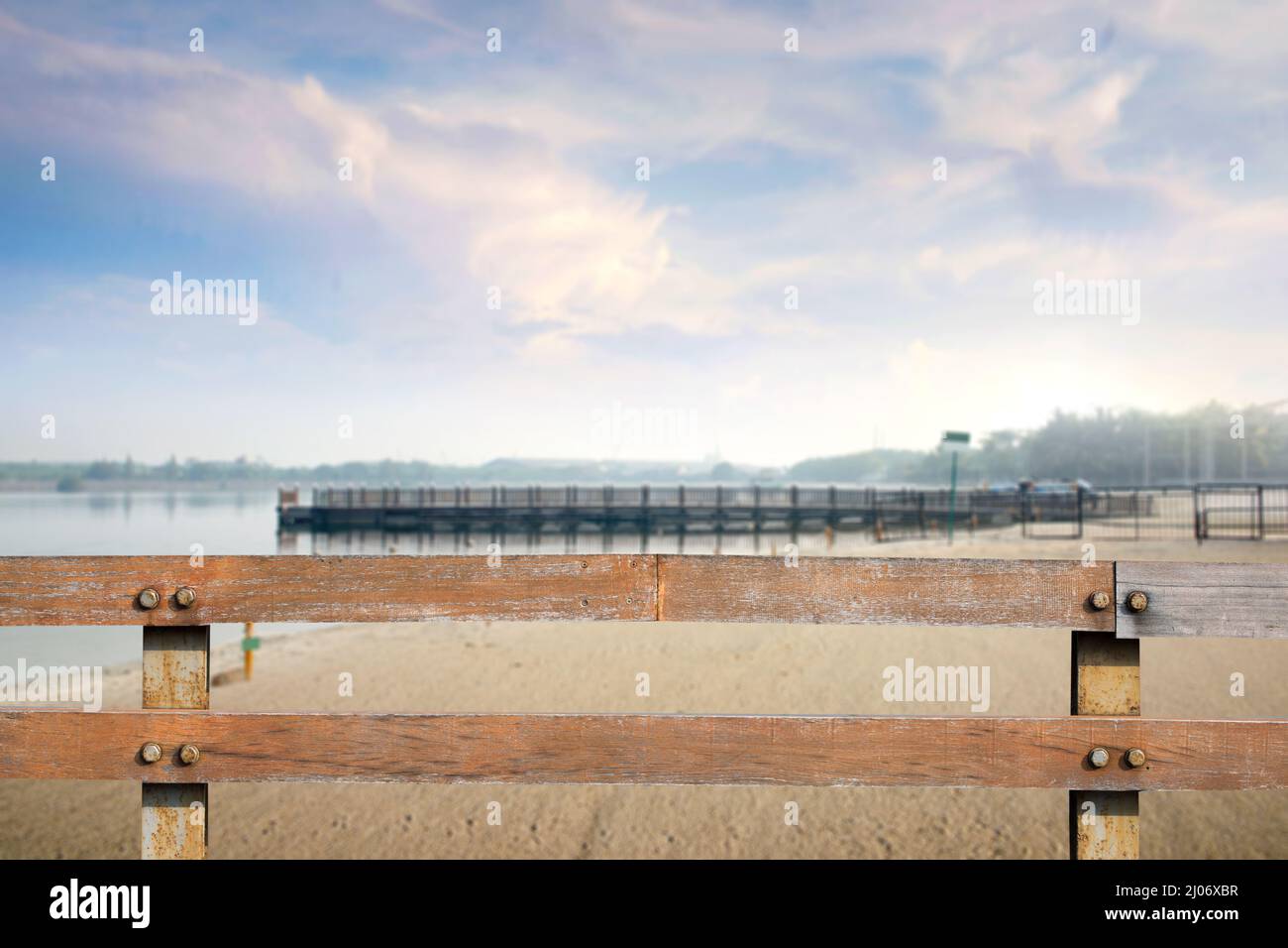 Wooden fence with wooden dock view on the lake with blue sky background ...