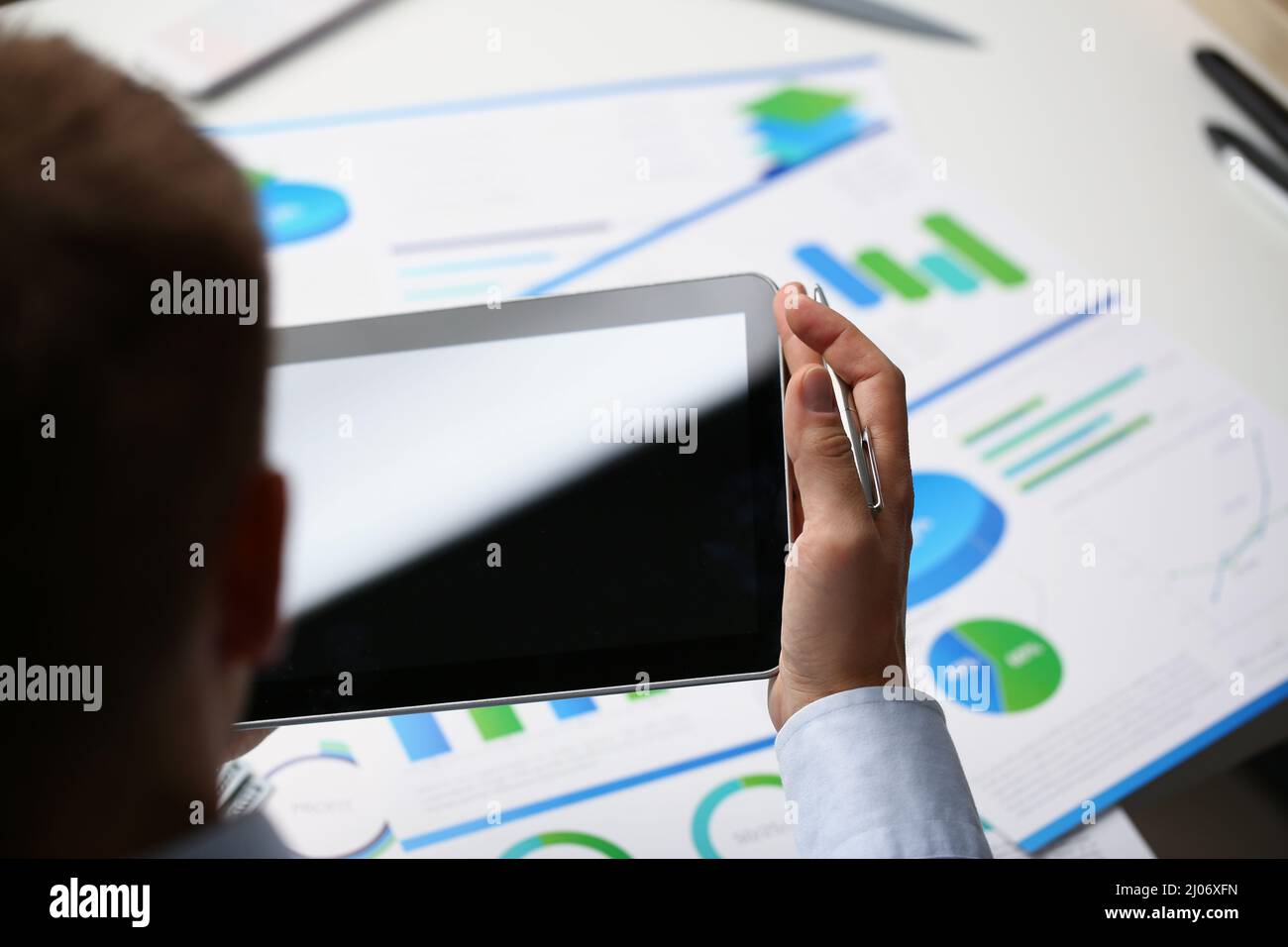 Man use tablet, black screen, papers with diagrams and charts on ...