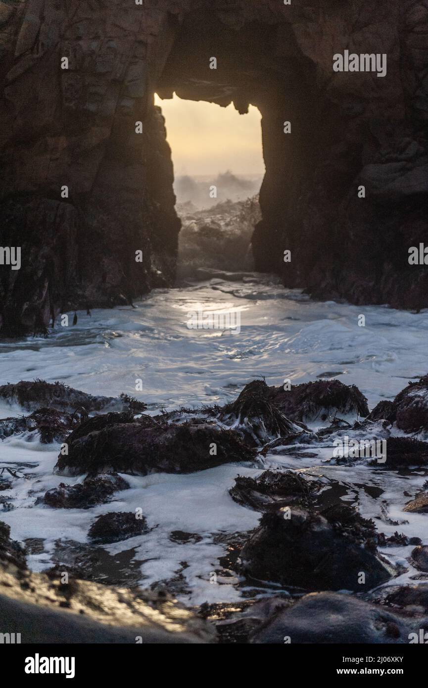 A sunset sky peeping thought the keyhole arch at Pfeiffer Beach, near ...
