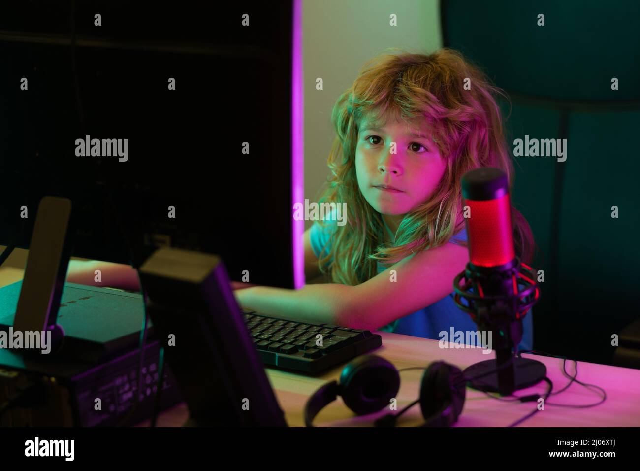 Little kid using desktop pc by night, child boy illuminated by the blue ...