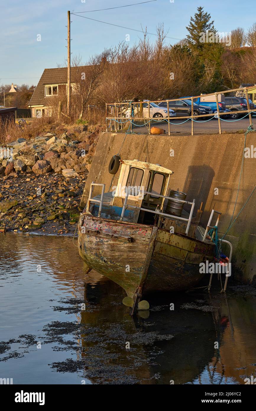 Old boat alongside a quay at low tide Stock Photo - Alamy