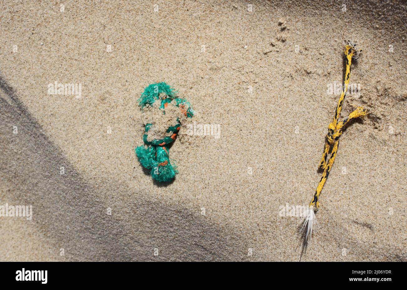 a piece of fishing net is lying on the beach in the sand and pollutes ...