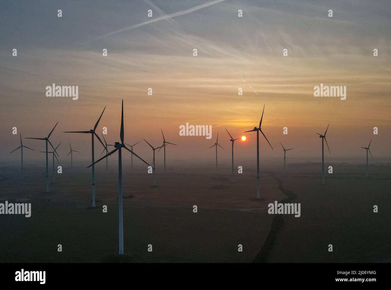 Jacobsdorf, Germany. 16th Mar, 2022. Sunset over wind turbines in the ...