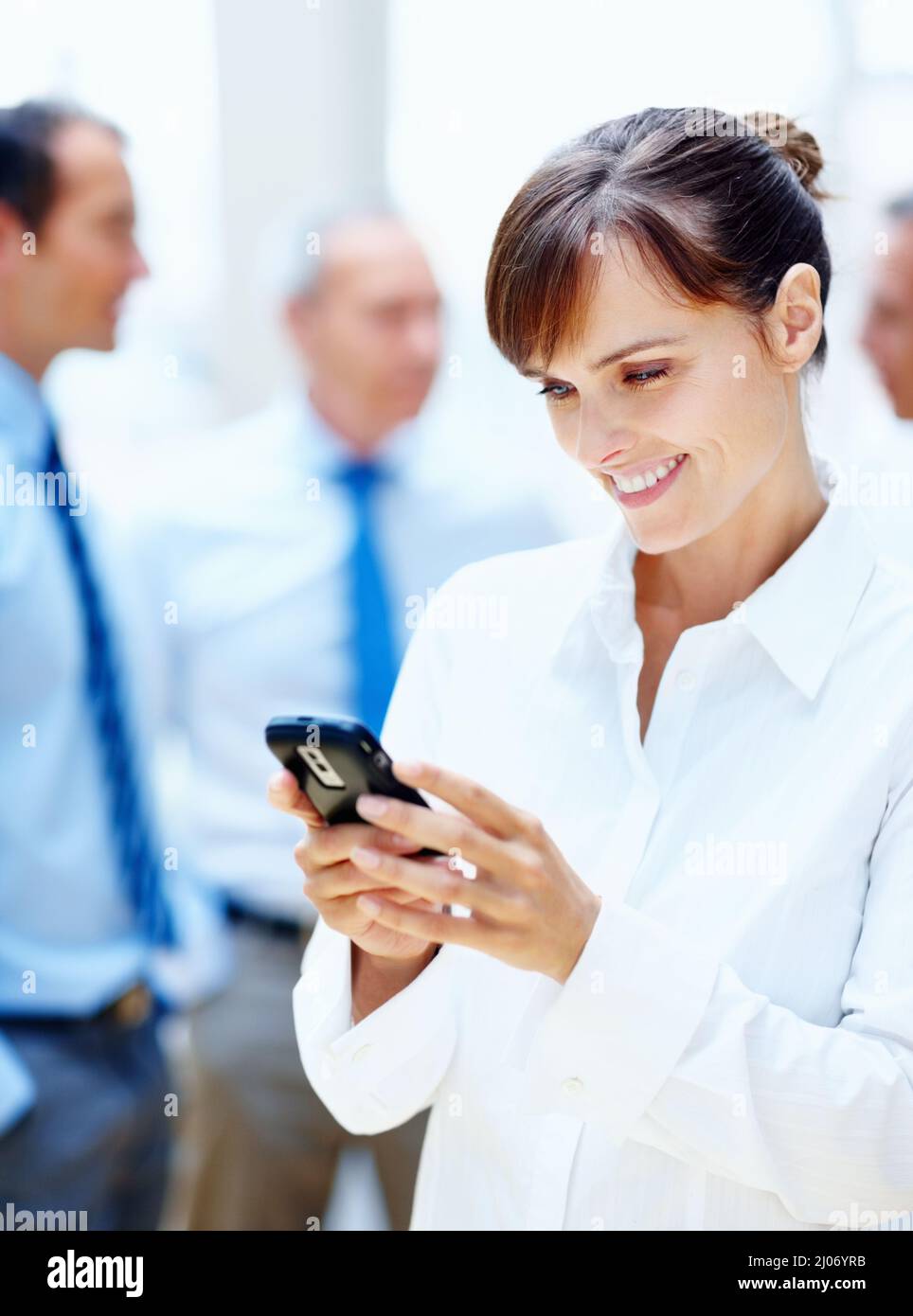 Happy female executive checking cell phone. Female executive at the ...