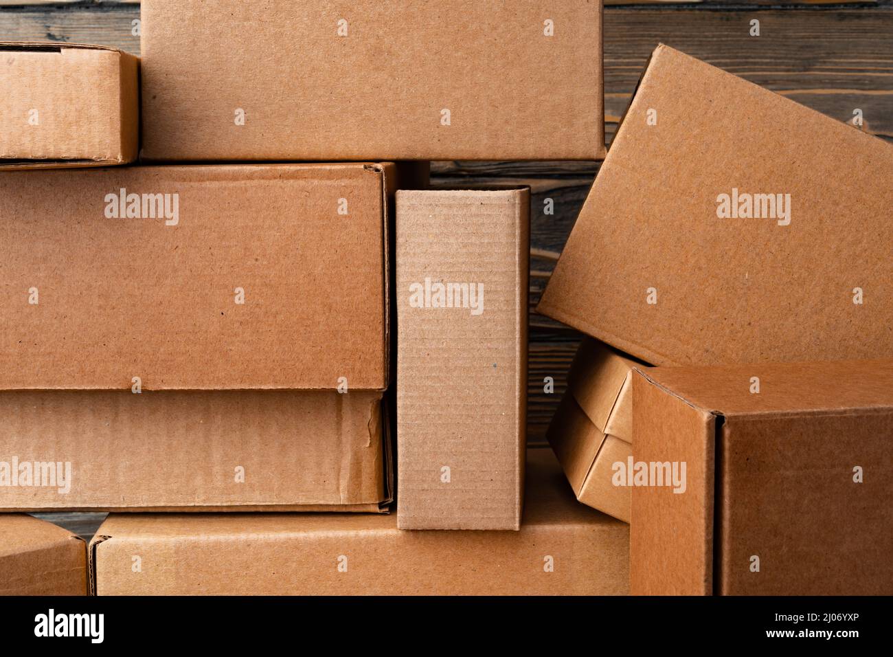 Pile of cardboard boxes on wooden background Stock Photo - Alamy
