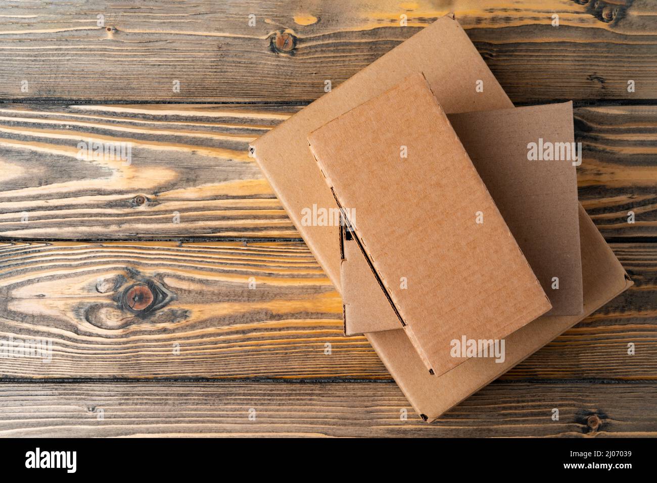 Pile of cardboard boxes on wooden background Stock Photo - Alamy