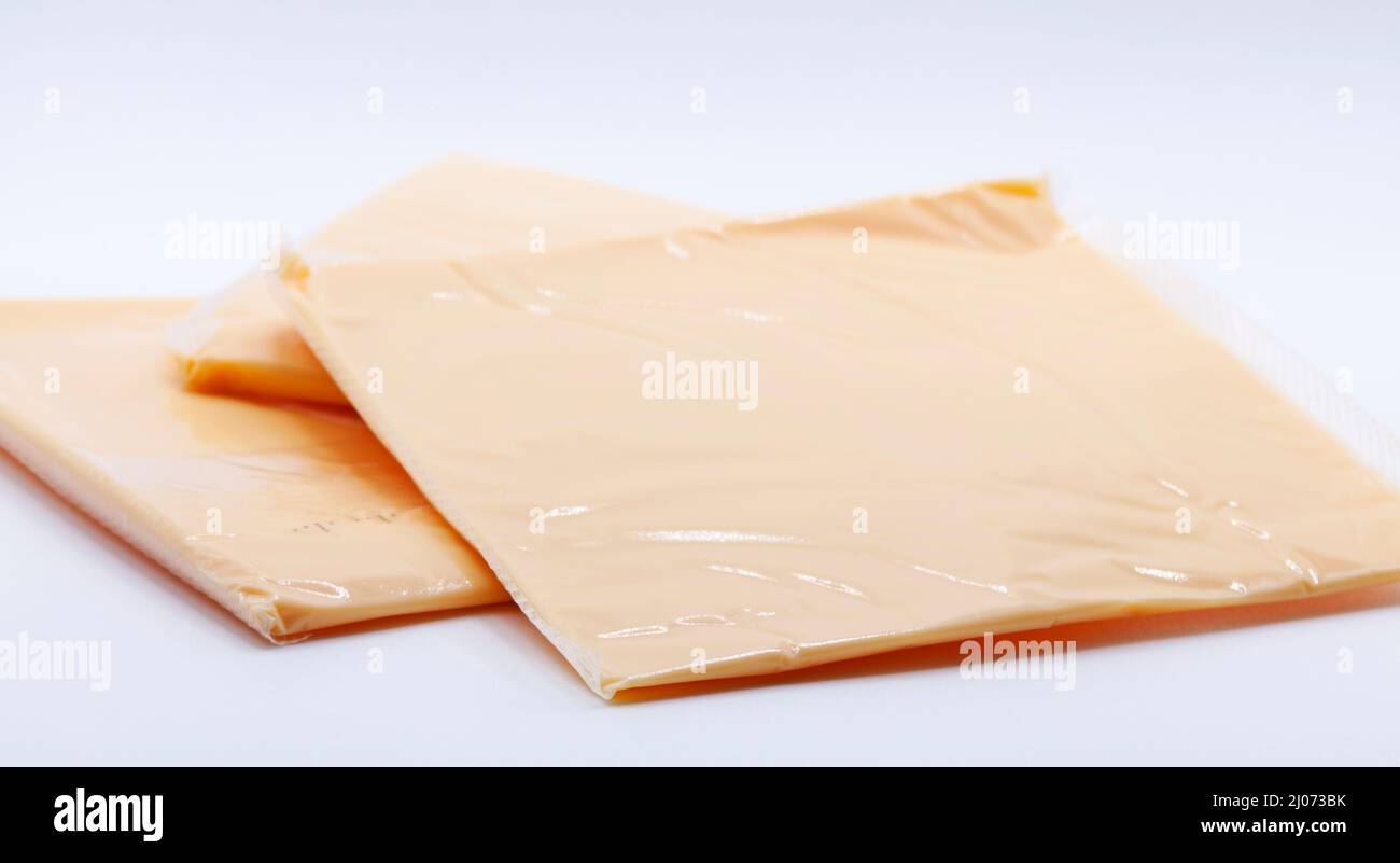 sliced pieces of cheese in plastic on white background Stock Photo - Alamy