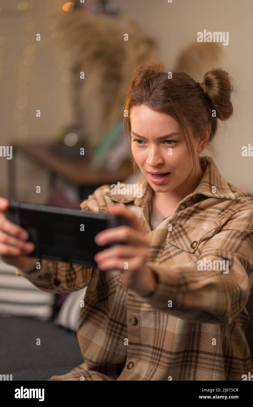 Player plays on portable console, young girl with smile plays on ...