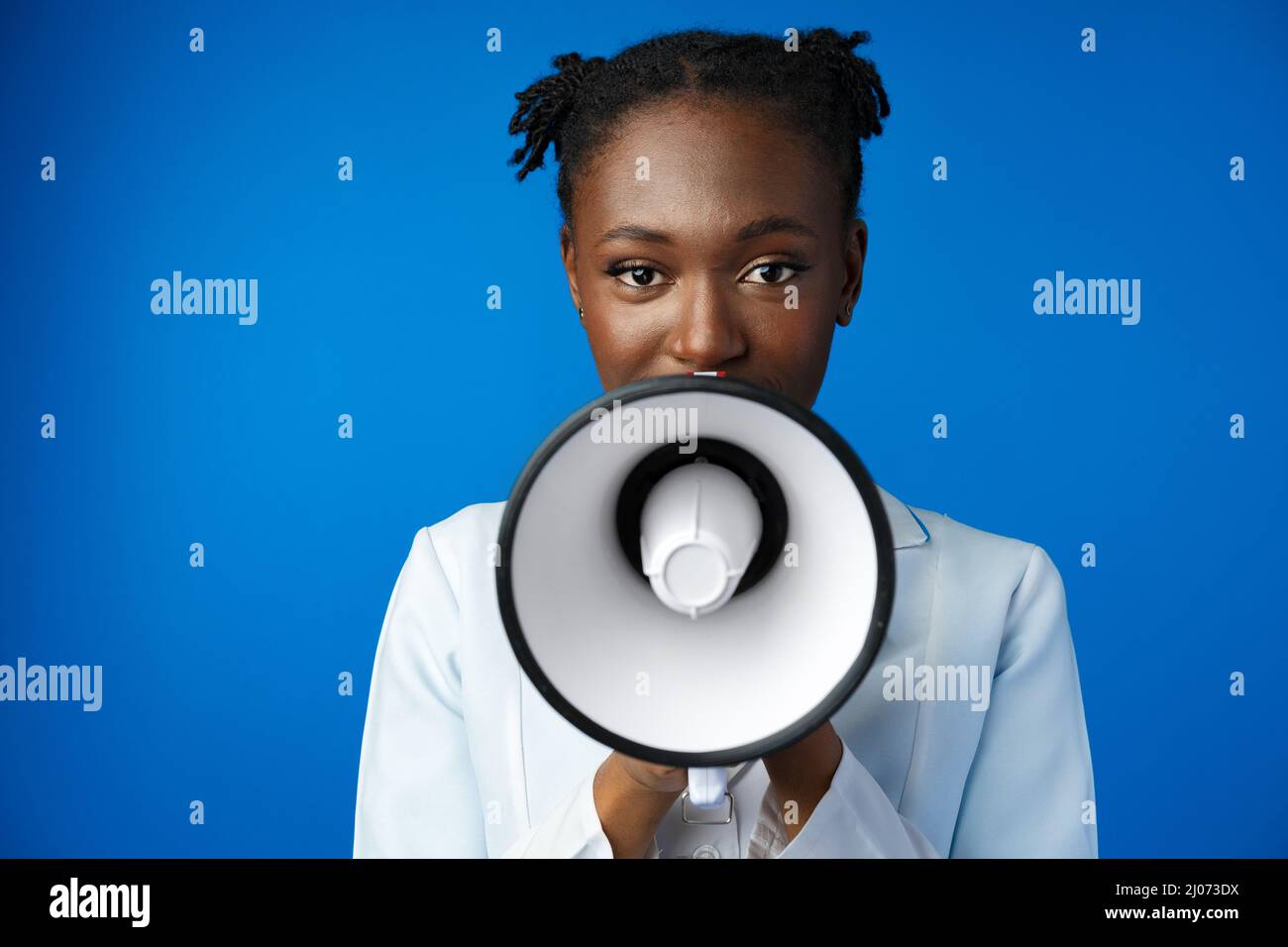 Afro american female doctor in white medical gown scream in megaphone ...