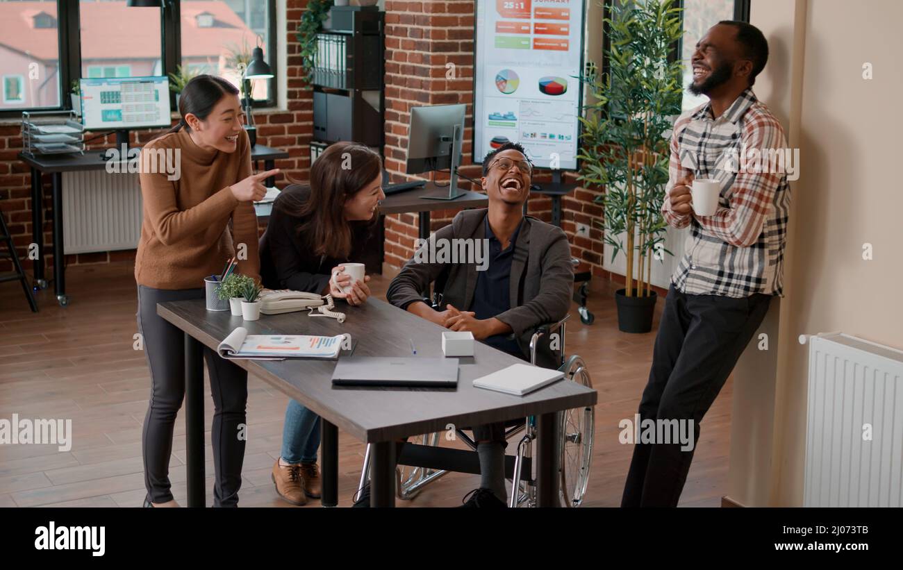 Diverse team of workers laughing together at startup job, brainstorming ...