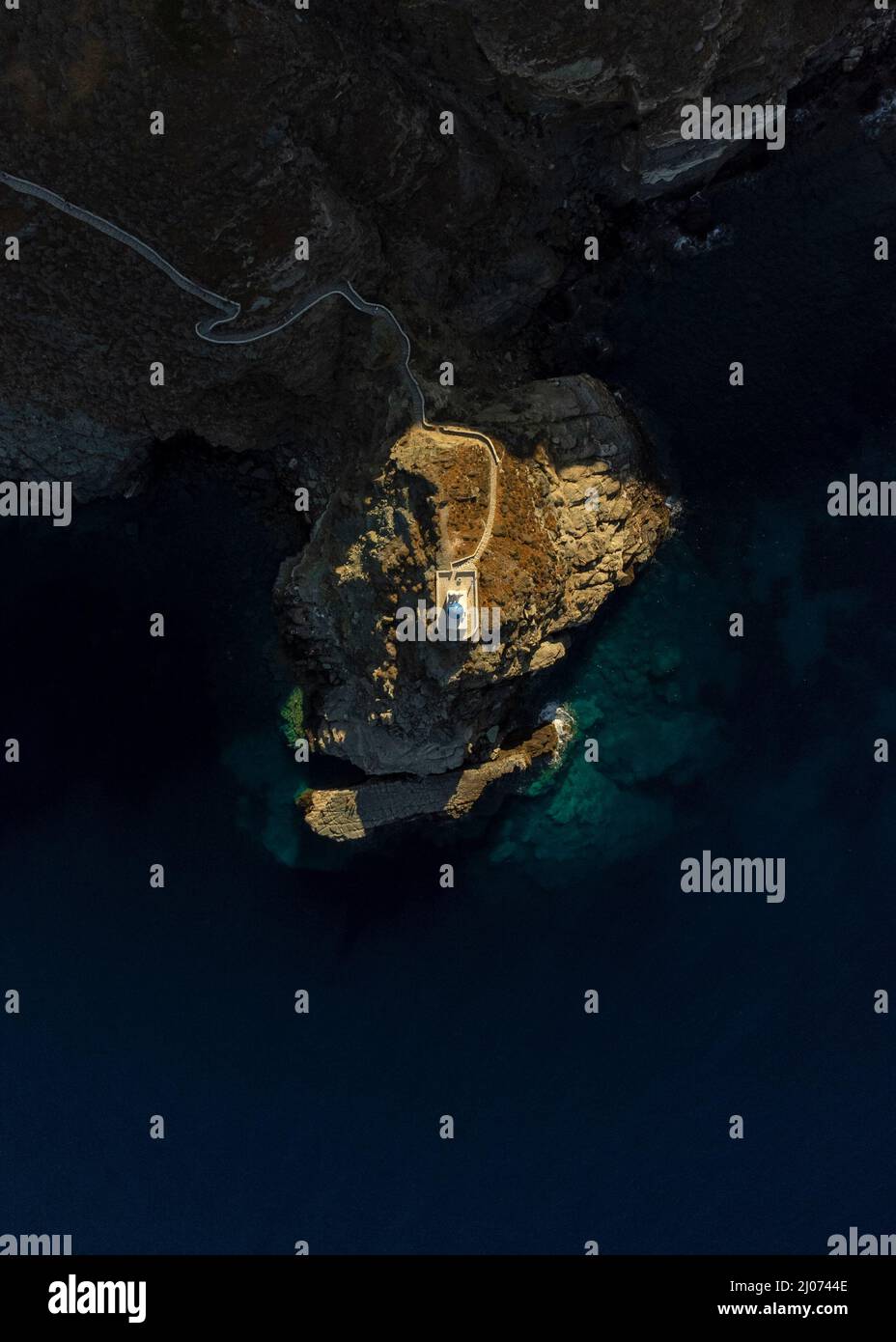 Vertical aerial view of the peninsula with lighthouse on it surrounded ...