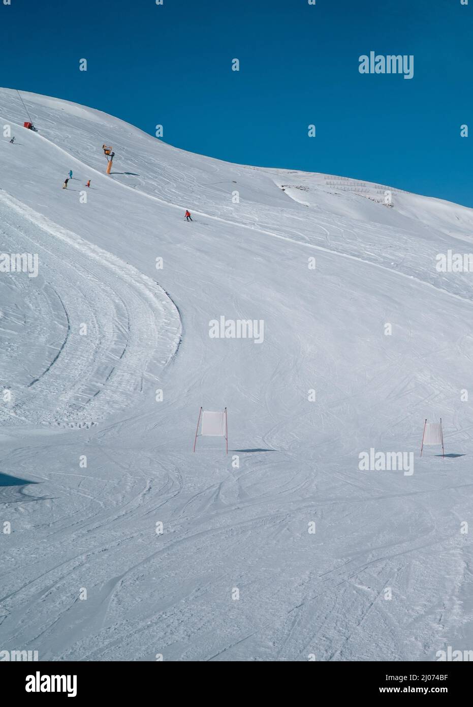 Vertical view of skiers skiing down slopes in the ski resort of Livigno ...
