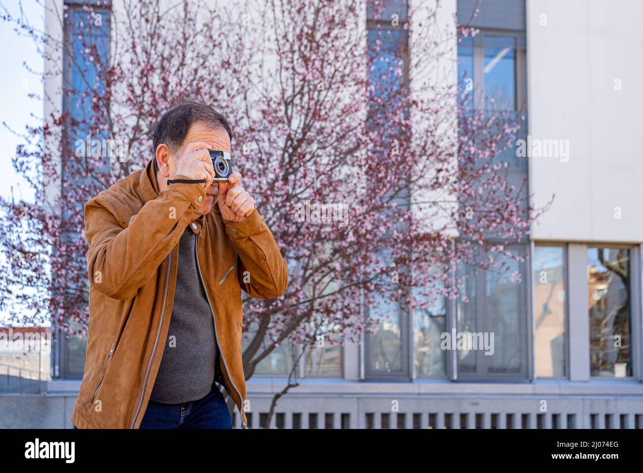 Older man taking a photograph with his old film camera Stock Photo - Alamy