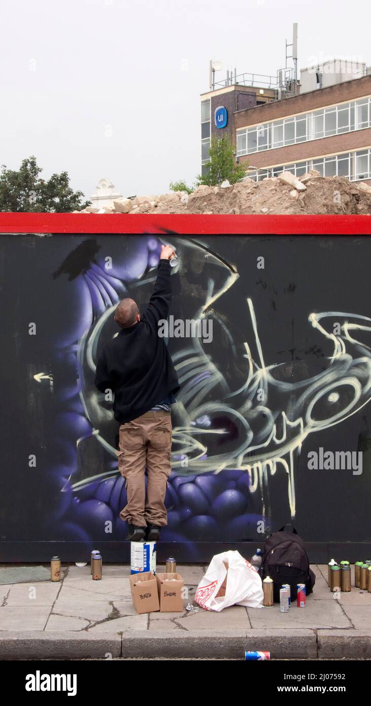 Graffiti show in Bacon St London E2. Artist working on building site ...