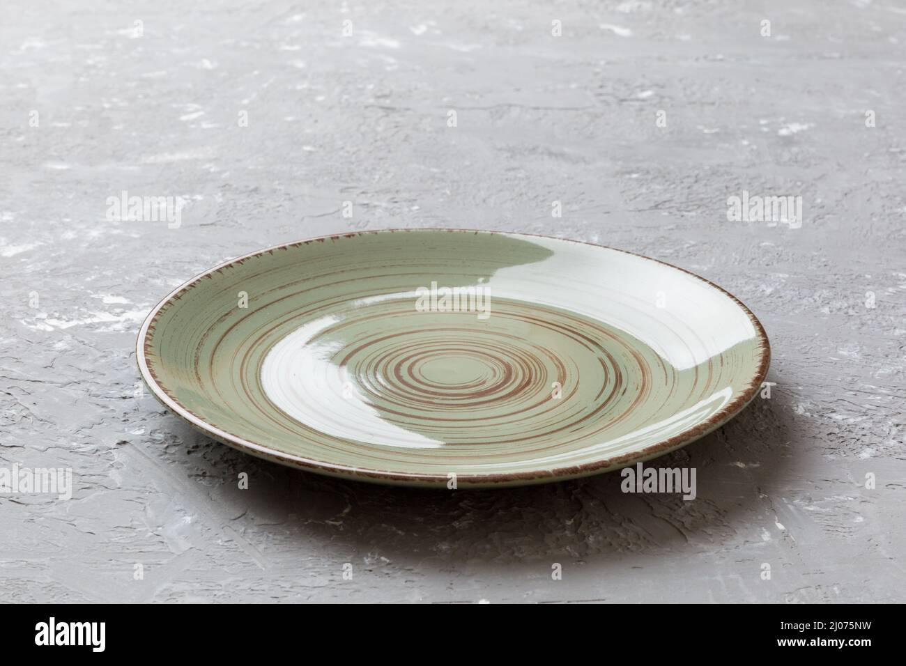 Perspective view of empty green plate on cement background. Empty space ...