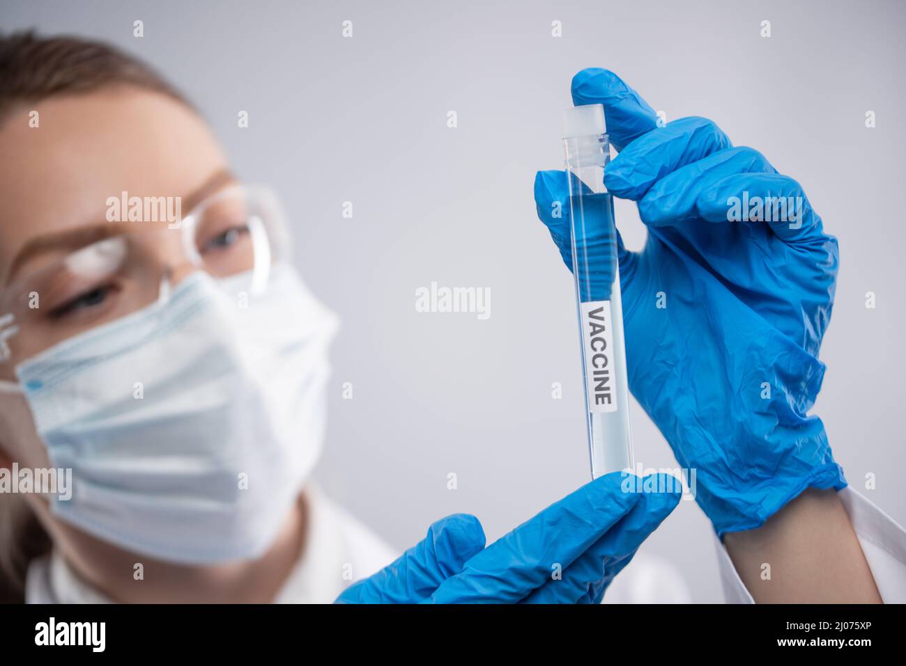 Close-up view of female microbiologist in protective gloves and face ...