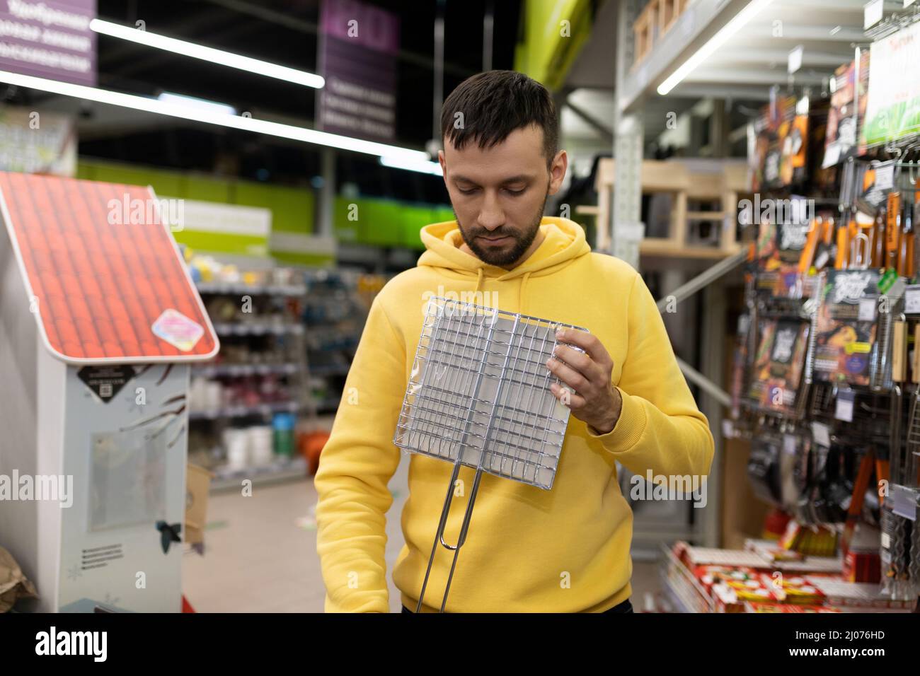 a customer in a hardware store chooses a new grate for grilling and ...