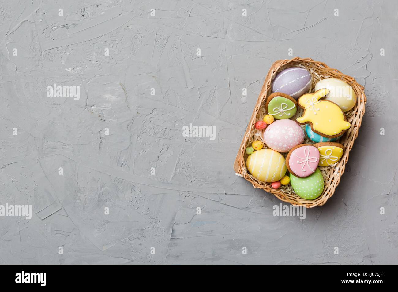 Multi colors Easter eggs in the woven basket on colored background ...