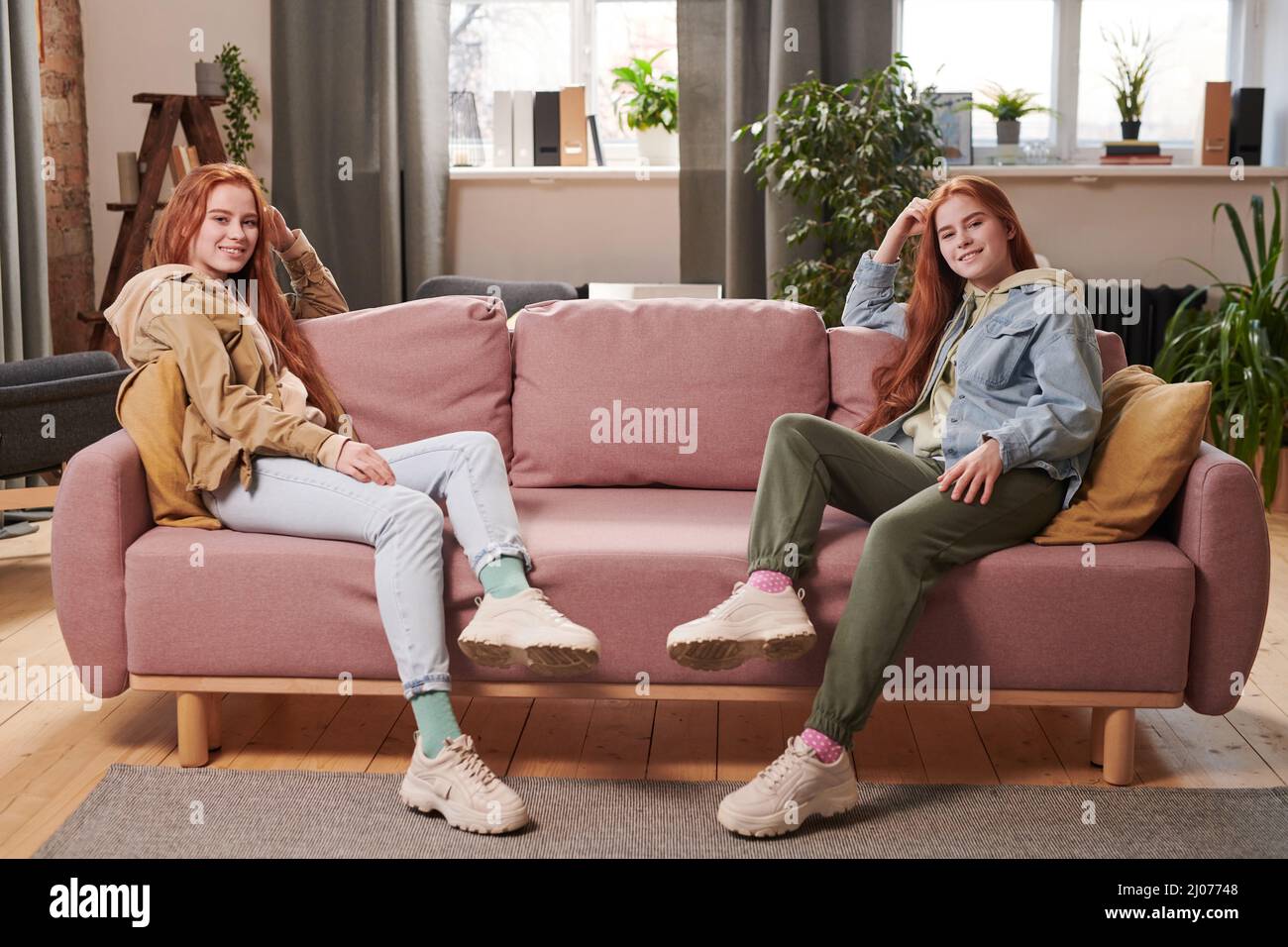 Wide shot of two beautiful young Caucasian twin sisters with long red ...