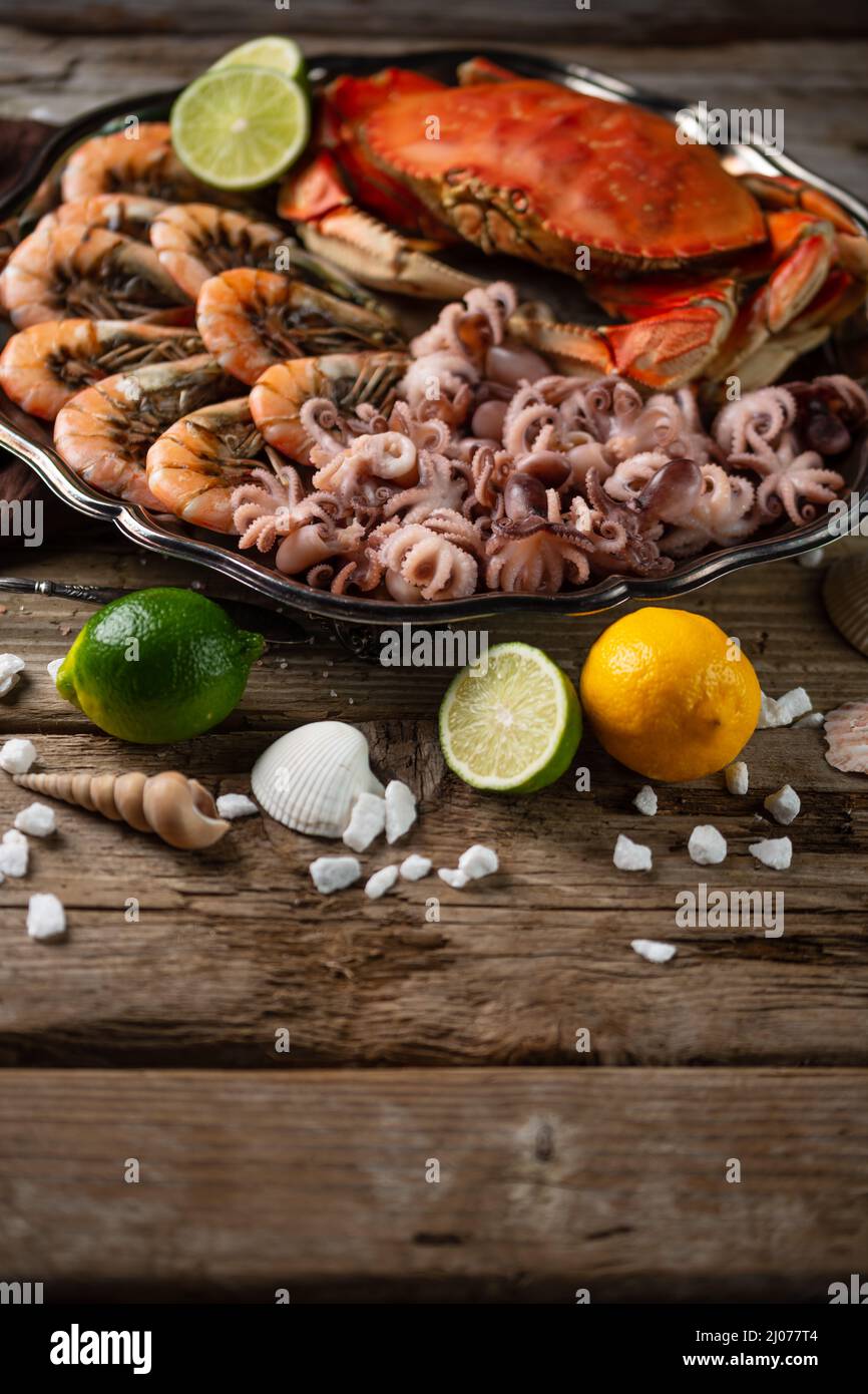 Side view of dish with assorted seafood served with spices on rustic ...