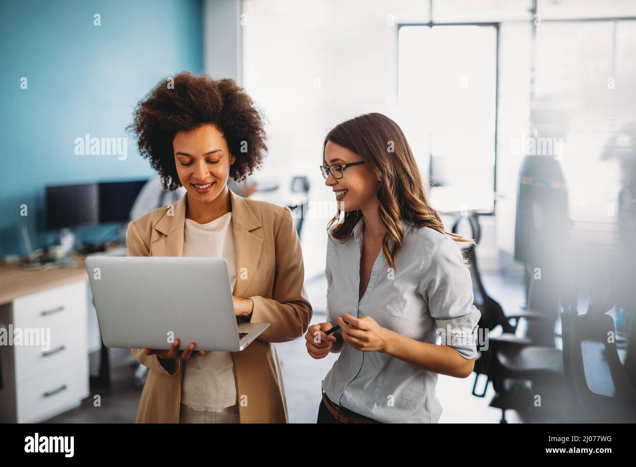 Happy multiethnic smiling business women working together in office ...