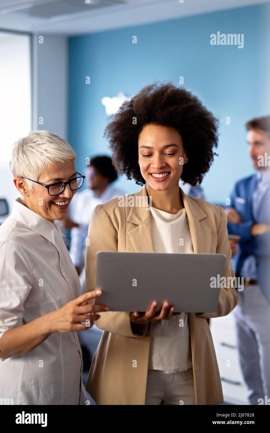 Happy multiethnic smiling business women working together in office ...