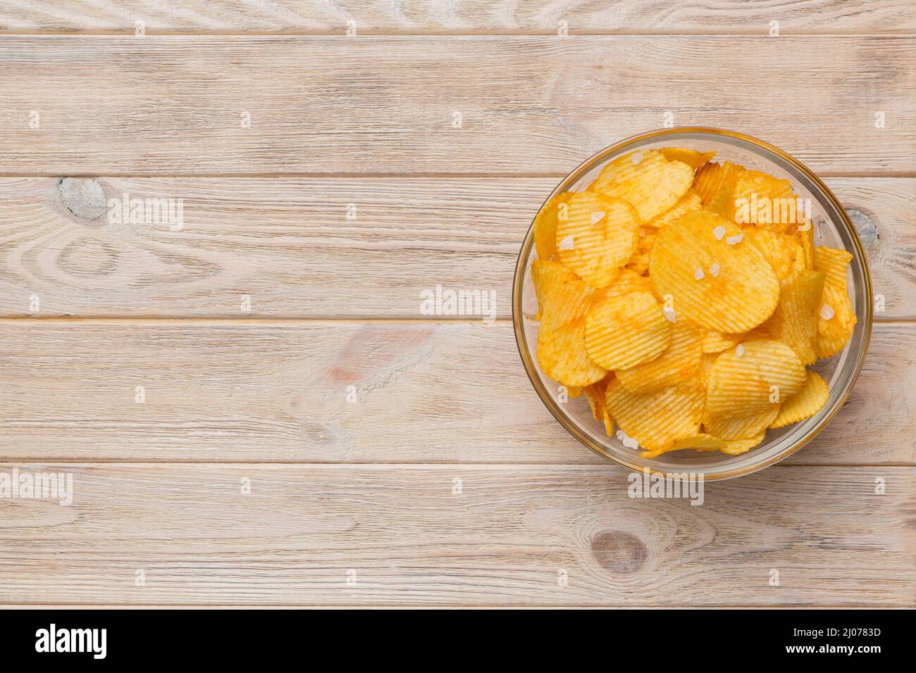 Potato chips on bowl isolated on colored background. Delicious crispy ...