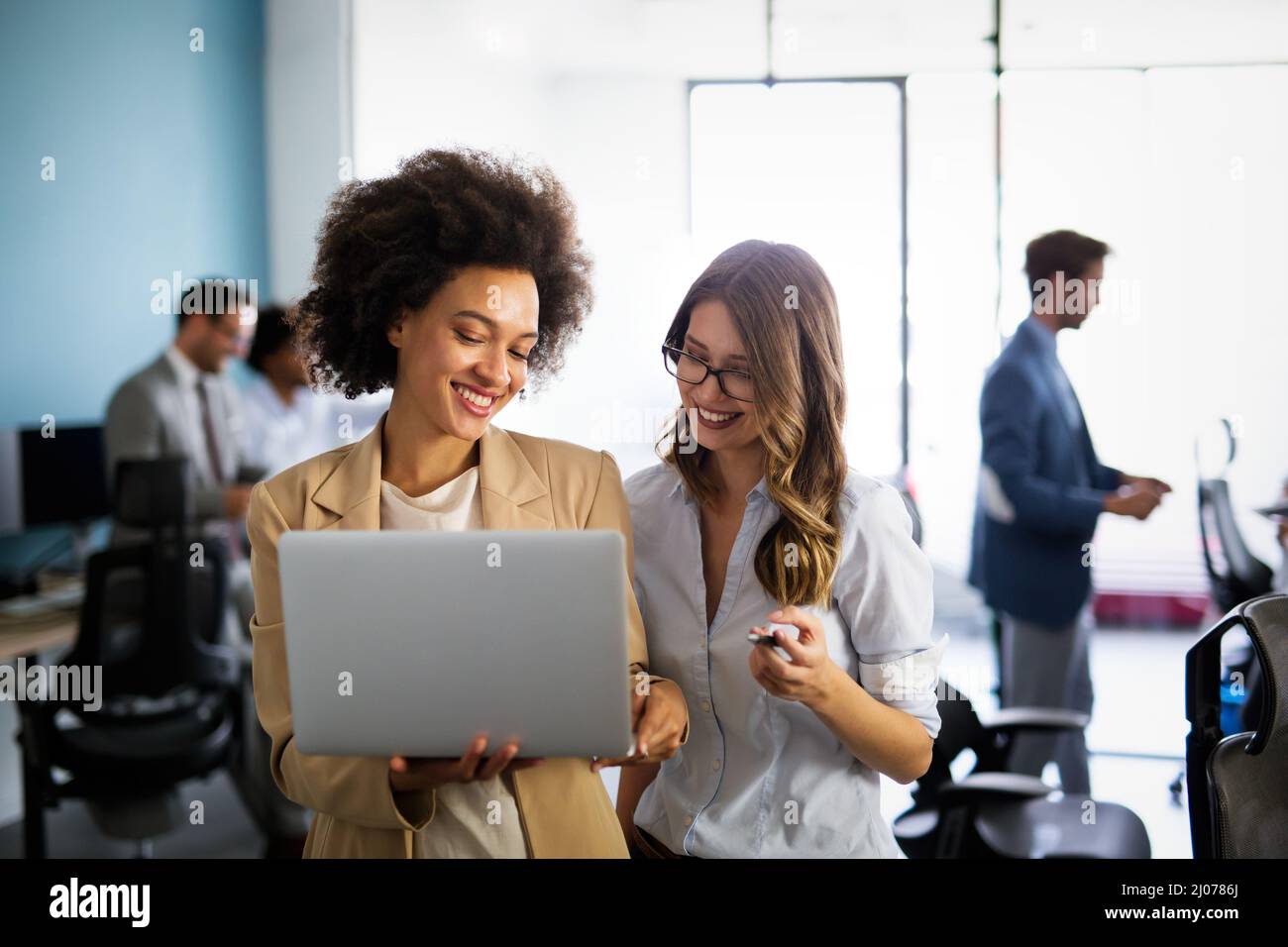 Happy multiethnic smiling business women working together in office Stock Photo - Alamy