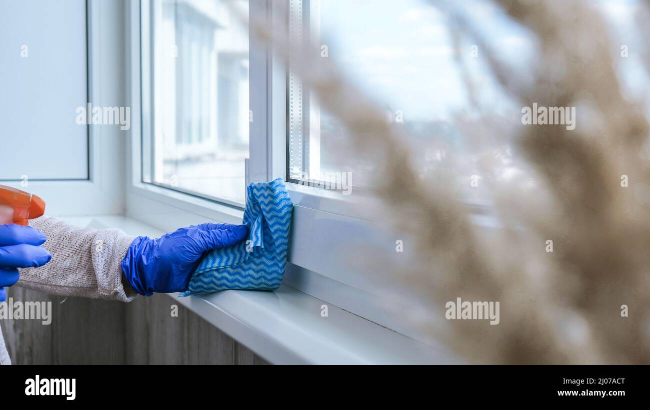 Cleaning the windowsill wiping dust by blue microfiber cloth for ...