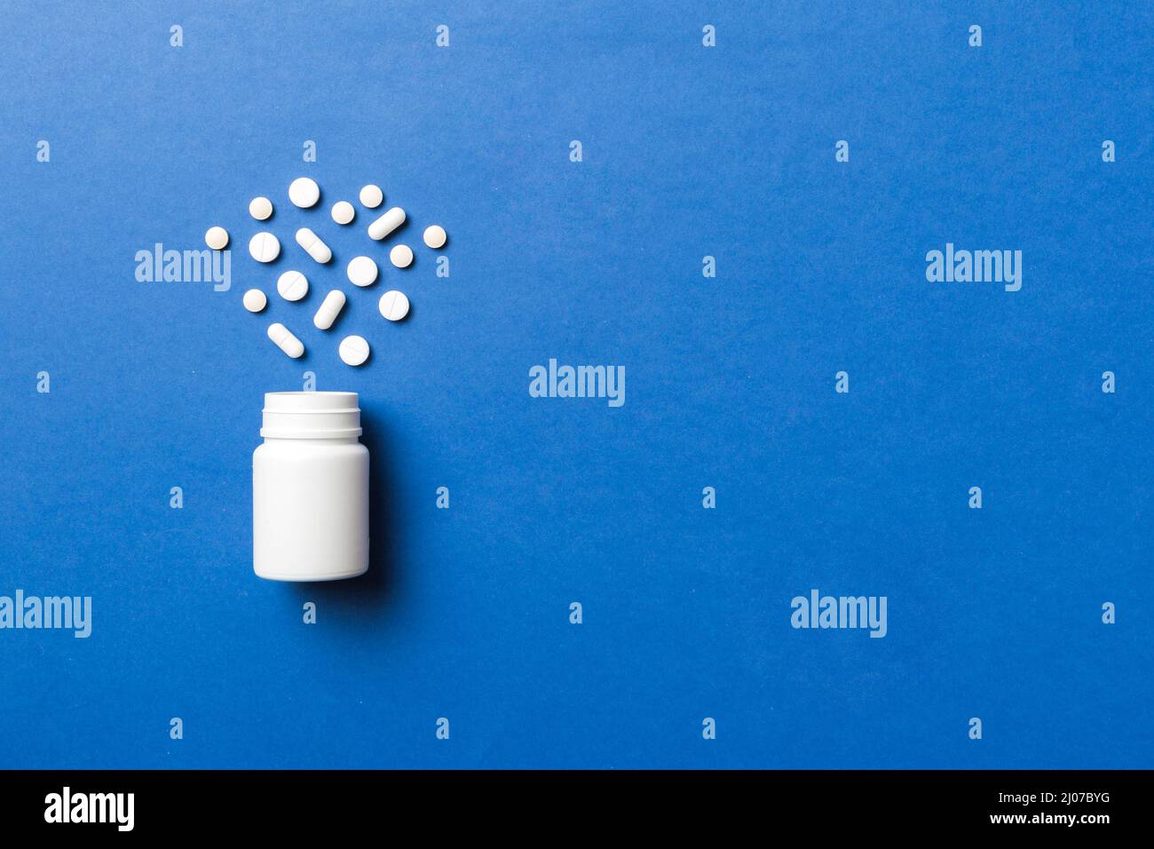 Multicolored pills and capsules in plastic bottle on Colored background ...