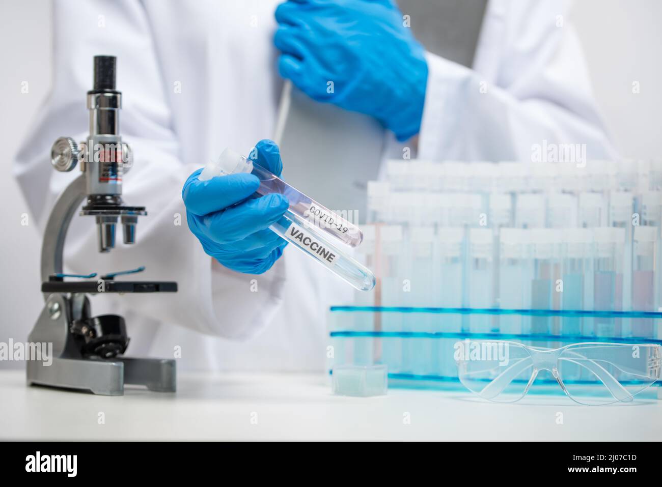 Close-up view of female microbiologist in biohazard protective clothing ...