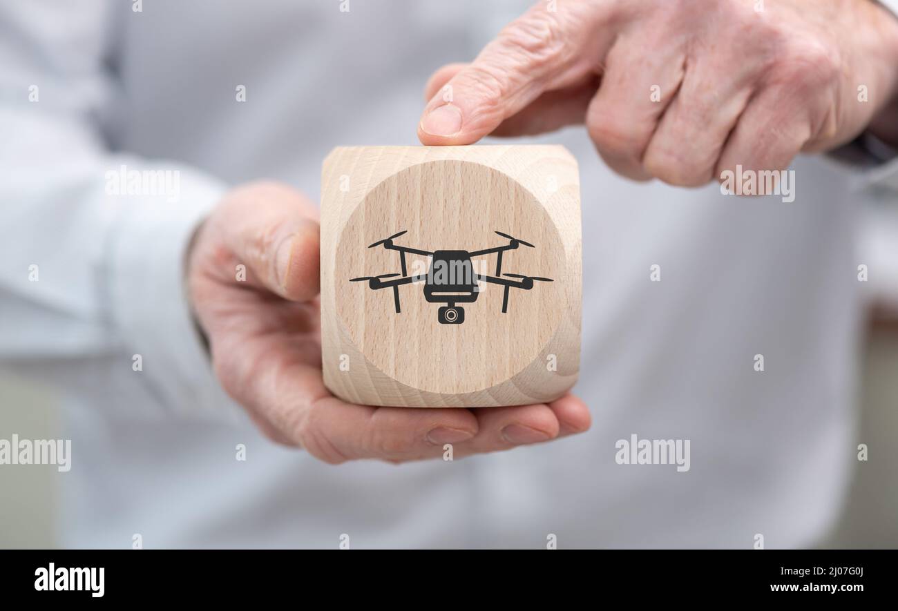 Hand holding a wooden cube with symbol of drone concept Stock Photo - Alamy