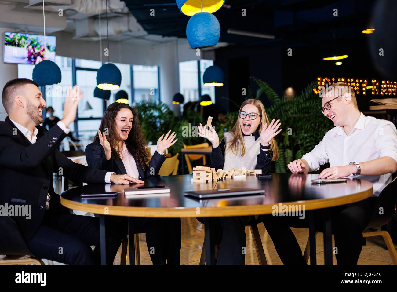 A company of colleagues in the office during a break plays the board ...