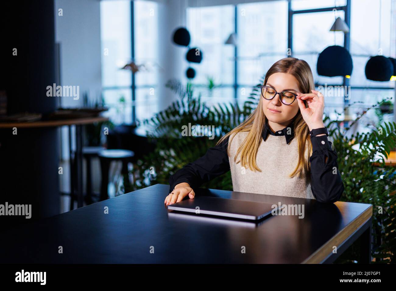 Young pretty woman businesswoman in glasses working at office desk in ...