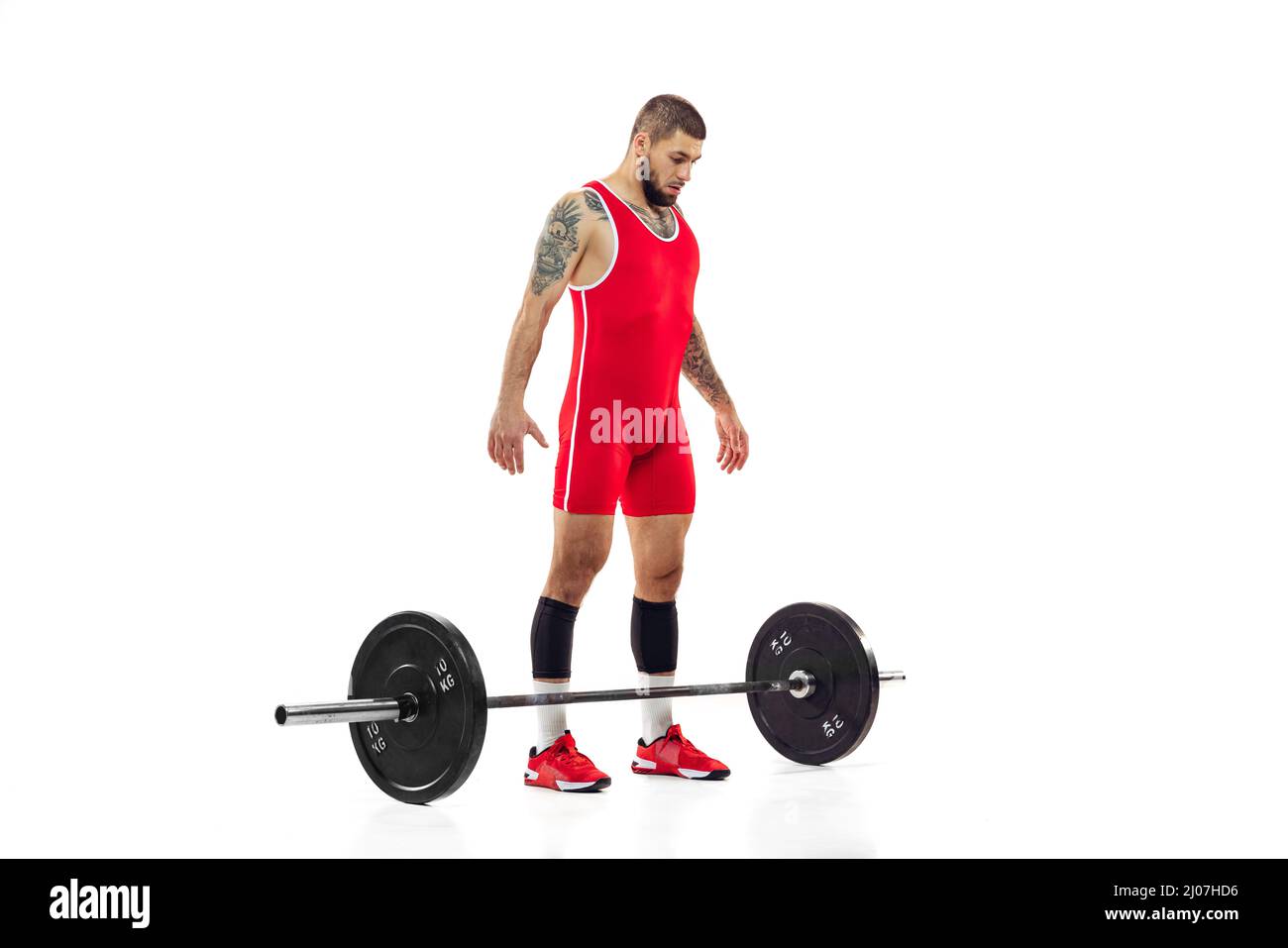 Full length portrait of man in red sportswear exercising with a weight ...