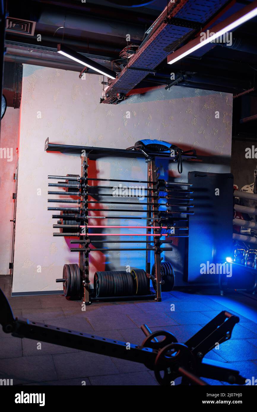 Rack in the gym with metal barbells for exercise. Squat bar with weight ...