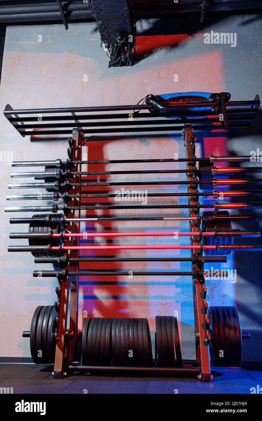 Rack in the gym with metal barbells for exercise. Squat bar with weight ...