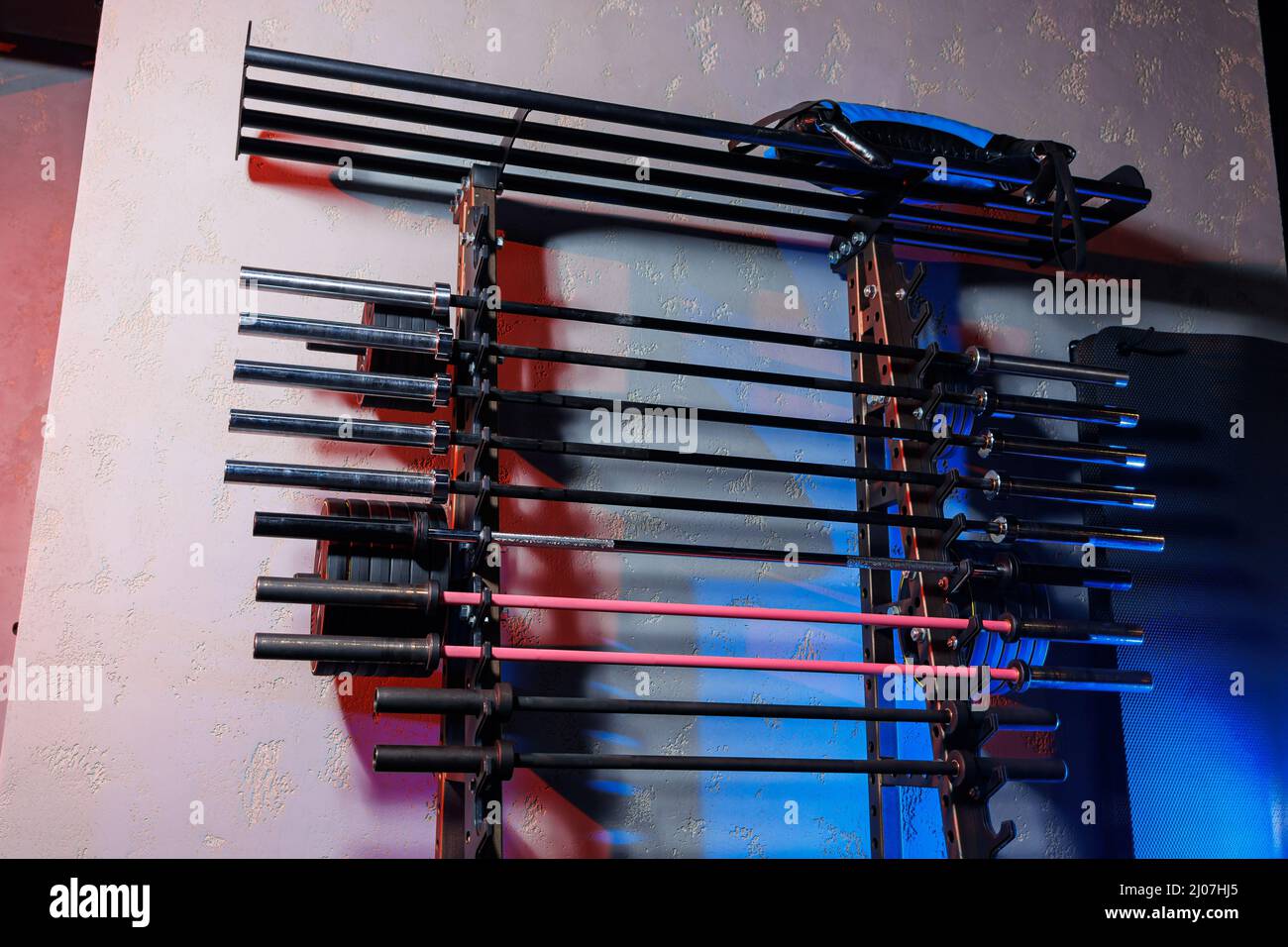 Rack in the gym with metal barbells for exercise. Squat bar with weight ...