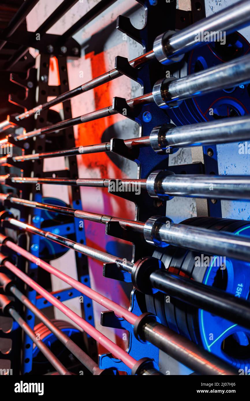 Rack in the gym with metal barbells for exercise. Squat bar with weight ...